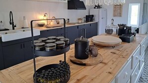Cozinha moderna com ilha central, armários pretos e lustre.