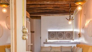 Uma sala de estar acolhedora com um sofá branco, mesa de centro de madeira e arte decorativa na parede.