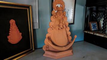 Escultura de uma figura com coroa e livro, colocada sobre um pedestal.