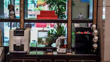 Estação de café com máquina de café, chaleira e suporte para xícaras.