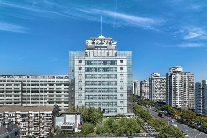 Um hotel imponente com vários andares, entrada destacada e vista ampla da paisagem urbana ao redor.