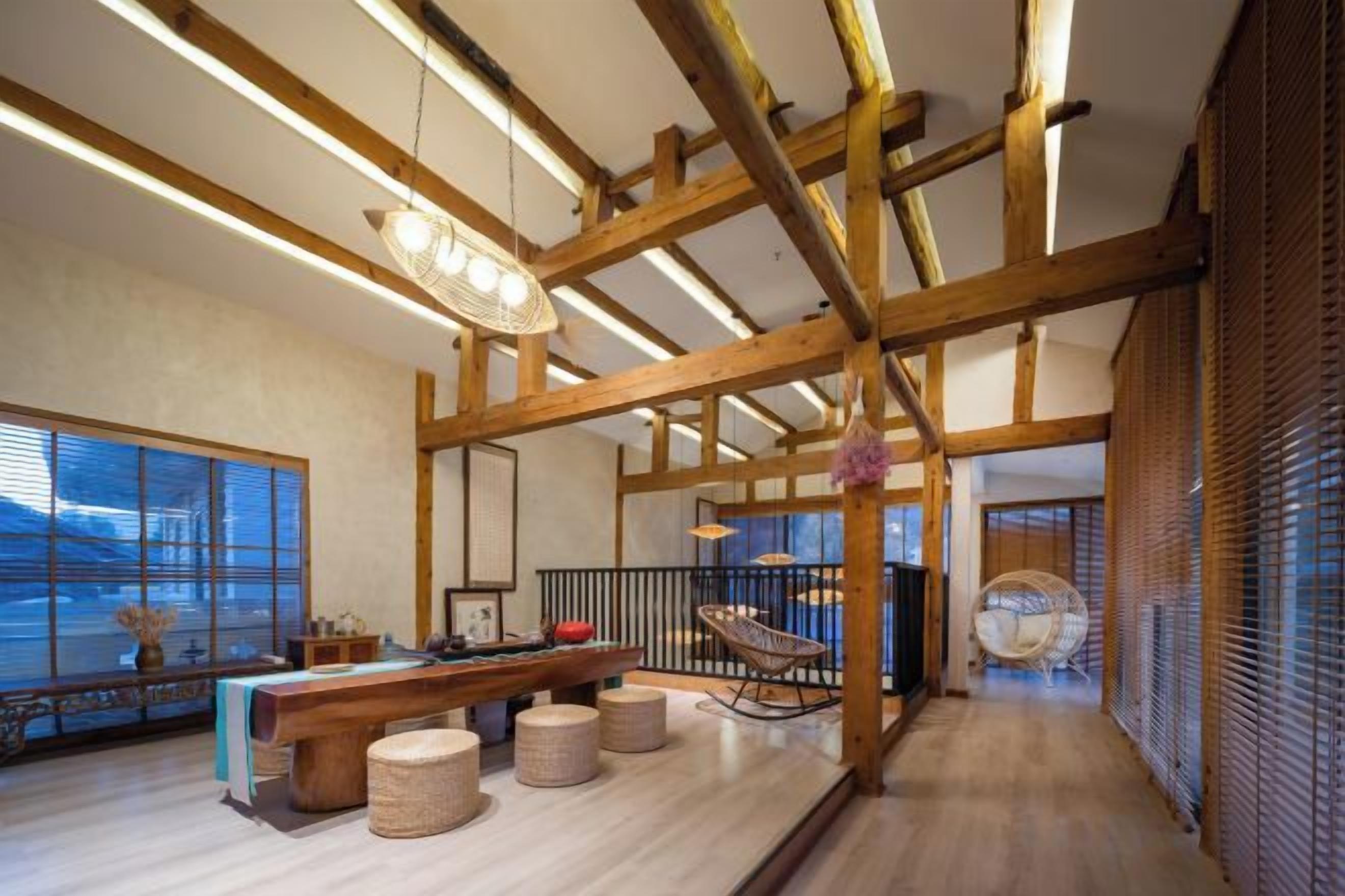 Quarto com estrutura de teto em madeira, área de refeições com mesa e cadeiras, e vista pela janela.