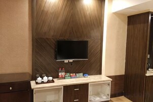 Casa de banho moderna com painel de parede de madeira, televisão montada e toucador com espelho e espaço de arrumação.
