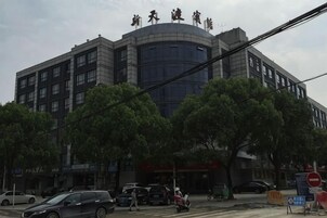Um edifício de vários andares com fachada curva e uma placa sobre a entrada.
