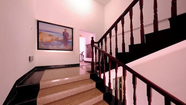Uma escadaria com corrimão de madeira e um quadro na parede.