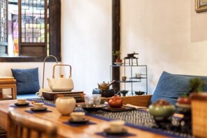 Uma mesa de madeira com um conjunto de chá tradicional, incluindo chaleira, xícaras e bandeja.