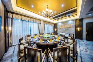 Espaço de refeições com mesa redonda, cadeiras e um candelabro.