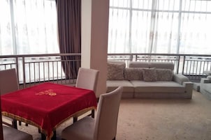 Varanda com mesa de jantar, cadeiras e sofá.