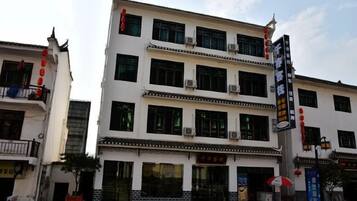 Edifício de vários andares com estilo arquitetônico tradicional, apresentando uma entrada central com marquise e uma placa de identificação acima.