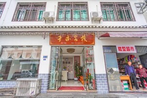 Fachada de loja com uma placa que diz 'Zhonghua Supermarket' e um vitrine com produtos.