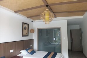 Quarto de hotel moderno com uma cama, cabeceira de madeira, luminária de teto trançada e um quadro na parede.
