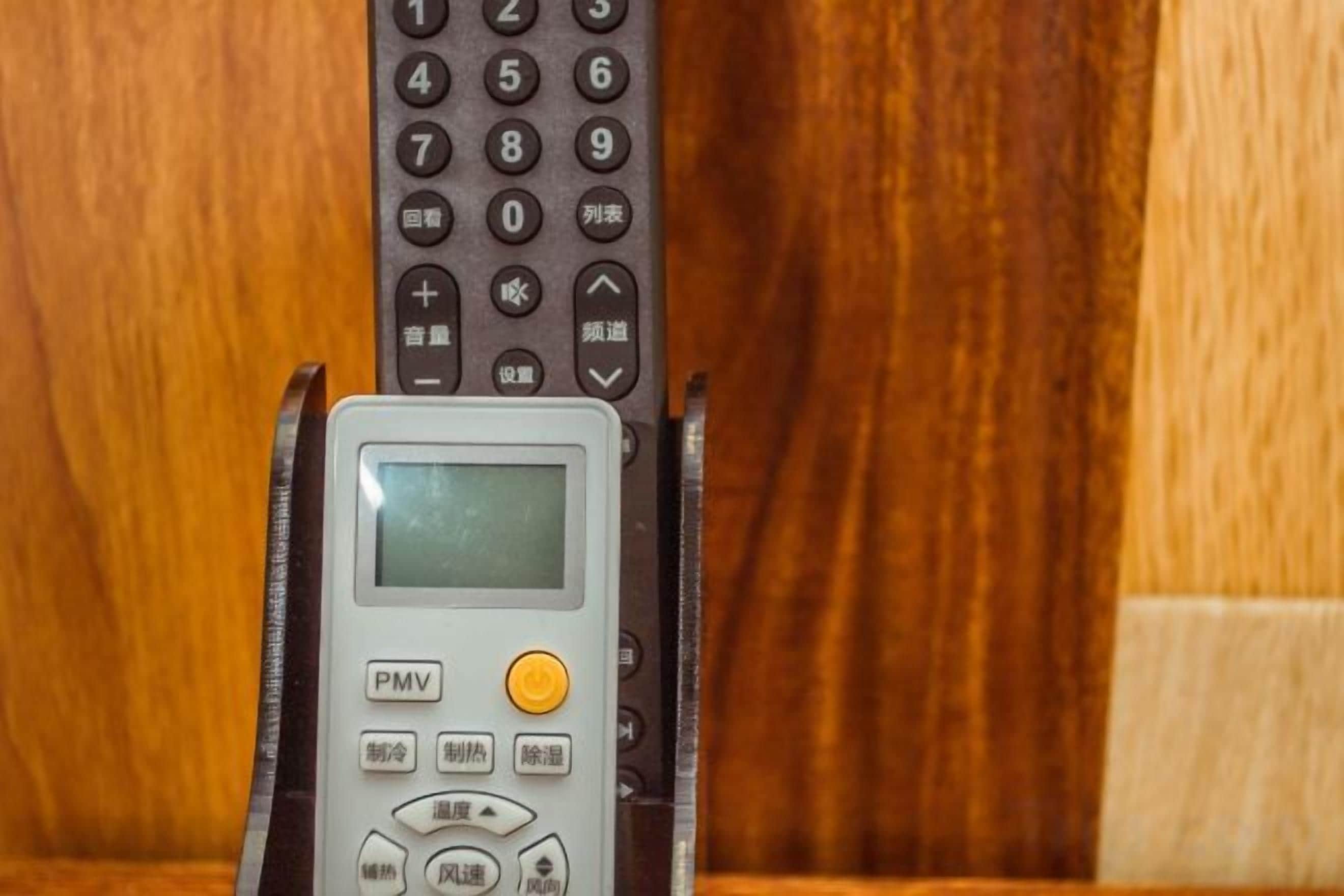 Calculadora e teclado telefônico sobre uma superfície de madeira.