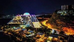 Um hotel com vários andares, com um edifício de cúpula marcante e uma estrutura curva.