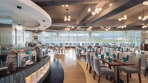 Um restaurante moderno com um balcão curvo, mesas e cadeiras.