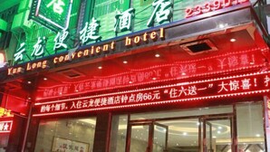 Um hotel com um letreiro de neon que indica ser um "Yun Long Convenient Hotel".