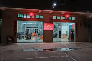 Um edifício com fachada de vidro e uma placa vermelha.
