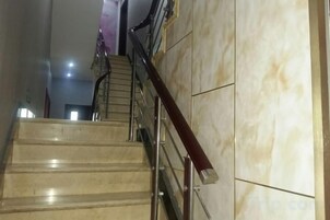 Uma escadaria de mármore com corrimãos de metal que leva a um andar superior.