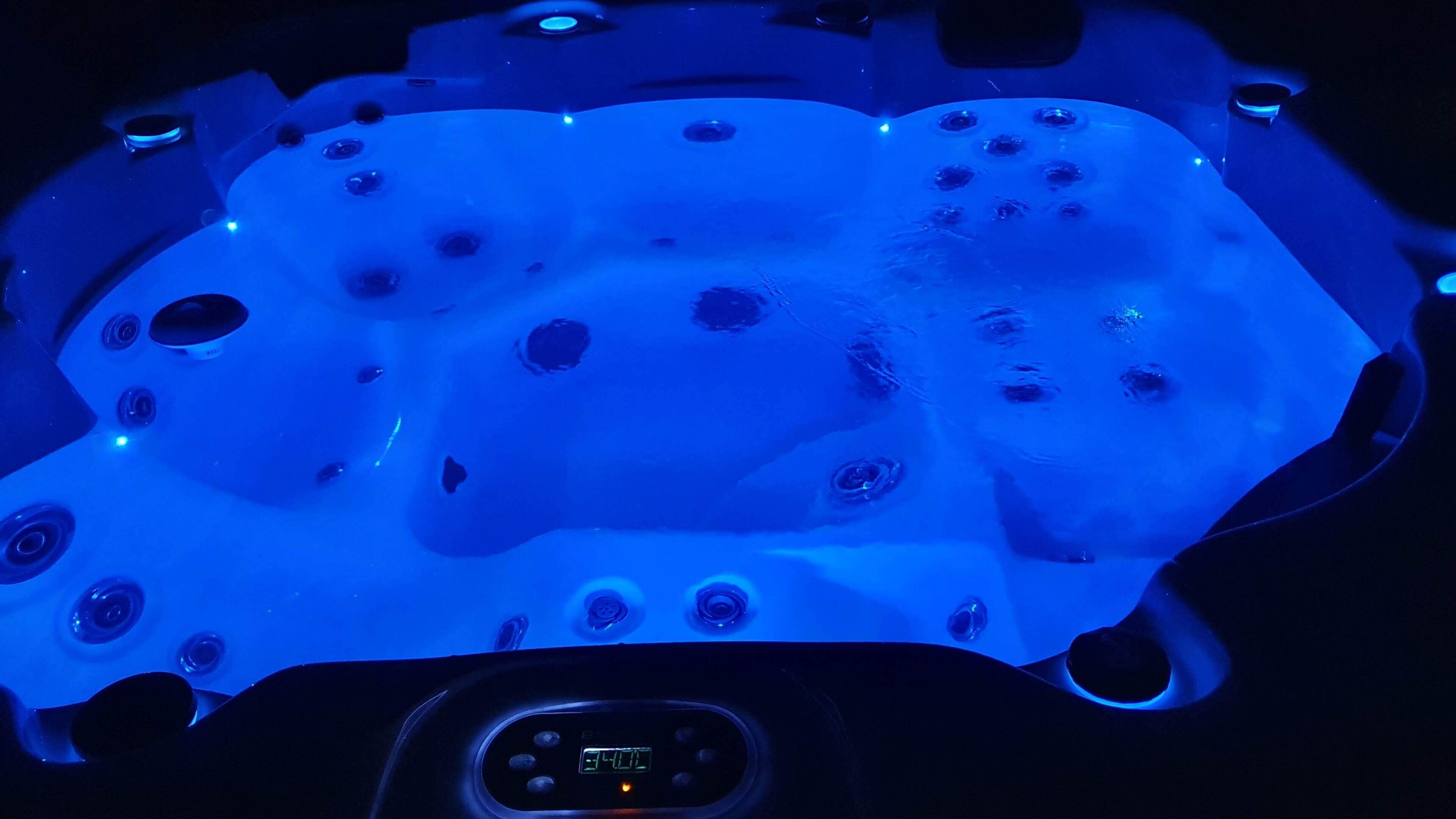 Uma banheira de hidromassagem com vários jatos, painel de controle e visor digital.