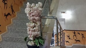 Uma escadaria com degraus de pedra e guarda-corpo de metal, decorada com silhuetas de animais nas paredes.