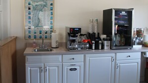 Cozinha com cafeteira, geladeira e pôster do Lago Michigan.