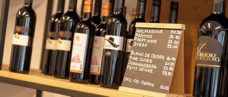 Uma estante de vinhos com várias garrafas e uma lista de preços.