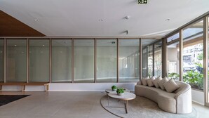 Um interior moderno com um sofá curvo, uma pequena mesa redonda e um banco.
