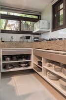 Cozinha com bancadas de granito, armários brancos, micro-ondas e fogão a gás.