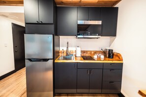 Um frigorífico/congelador grande, um micro-ondas, uma placa de cozinha