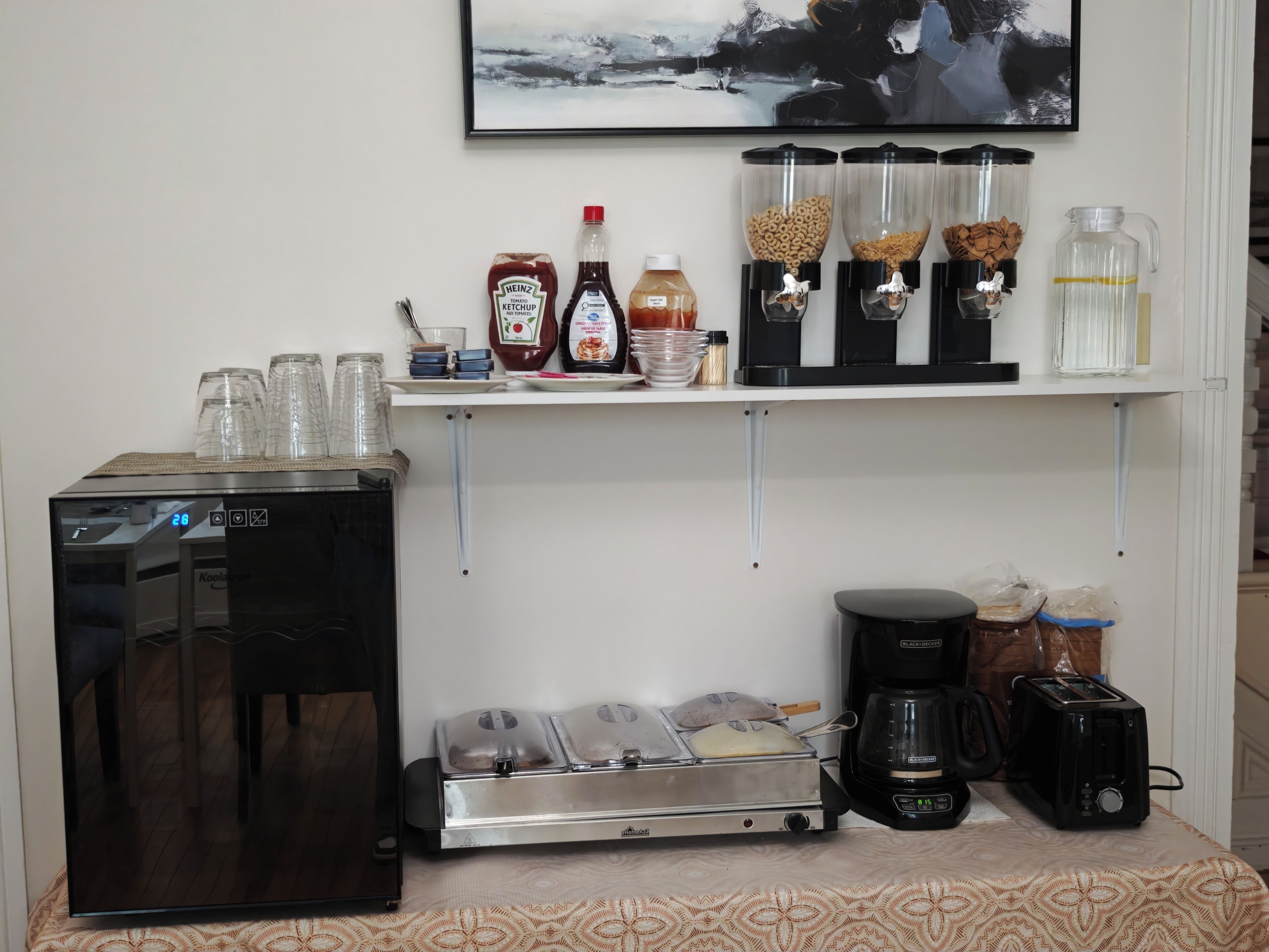 Uma cozinha compacta equipada com cafeteira, torradeira e recipientes para armazenar alimentos.