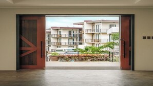 Um edifício moderno com uma grande porta aberta que dá para uma varanda.