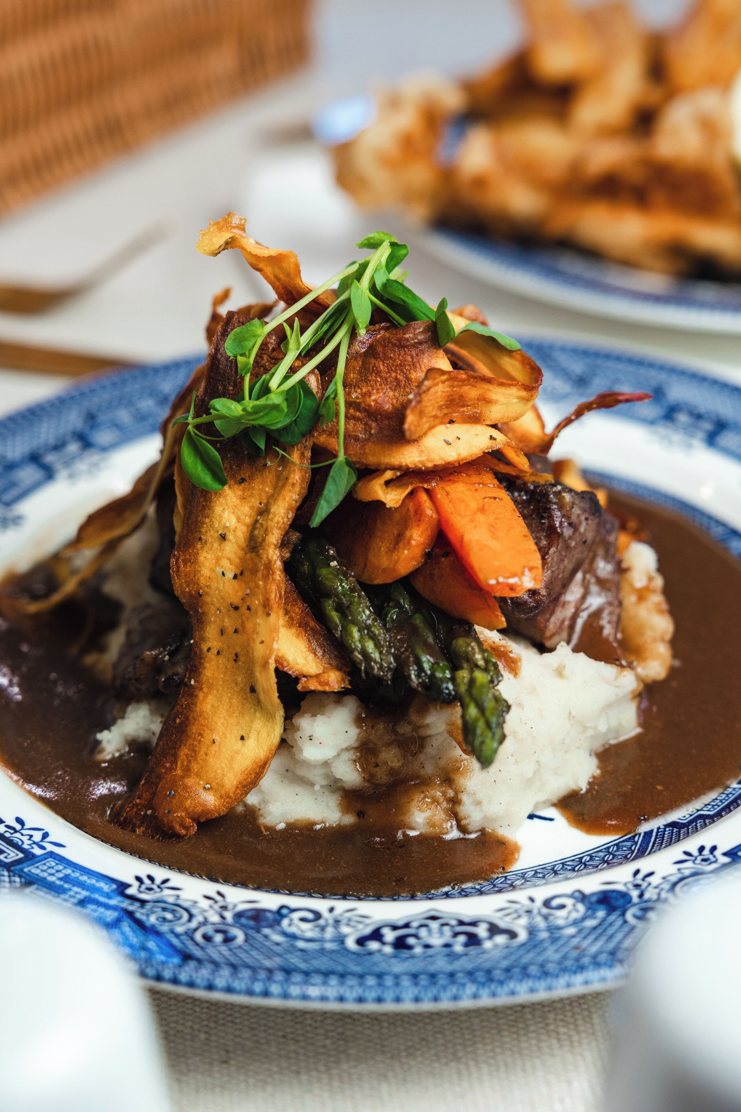 Um prato com bife, legumes e purê de batata.