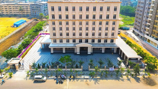 Um hotel com vários andares, um pátio central e um letreiro chamativo com a inscrição "Le Vivanta", além de edifícios ao redor.