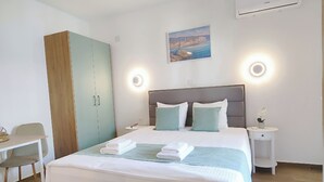 Quarto moderno com uma cama grande, mesas de cabeceira, um guarda-roupa e um quadro na parede.