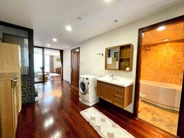 Uma casa de banho moderna com máquina de lavar roupa, lavatório e espelho.