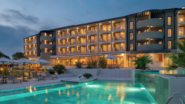 Um hotel com piscina, área de estar externa e várias varandas.
