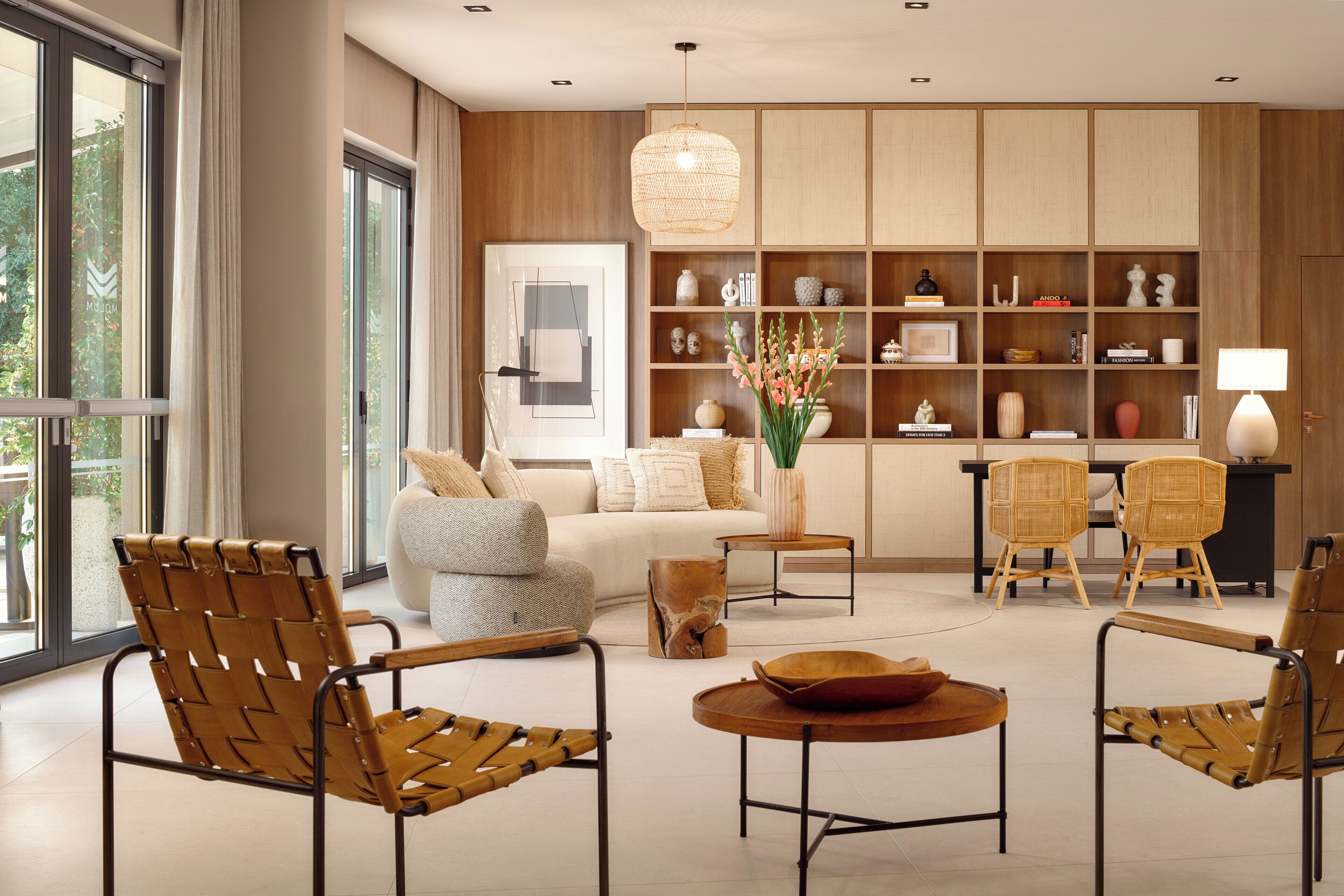 Uma sala de estar moderna com sofá, cadeiras, mesa de centro e estante.