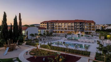 Um hotel com piscina, área de estar ao ar livre e parquinho.