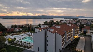Um hotel com piscina, arquitetura moderna e vista para o mar.