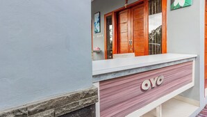 Casa de banho moderna com bancada branca, armários de madeira e um espelho com o nome 'Oyo'.