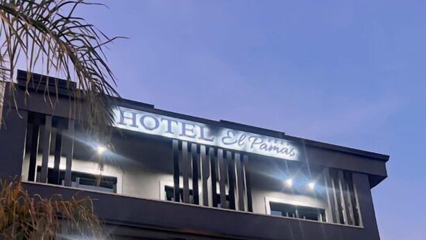 Um edifício de hotel moderno com uma placa que diz 'HOTEL El Paraiso'.