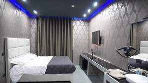 Quarto de hotel moderno com cama, toucador com espelho e lavatório.