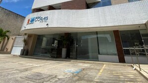 Hotel com design moderno, apresentando um telhado plano e fachada em tijolos e vidro.