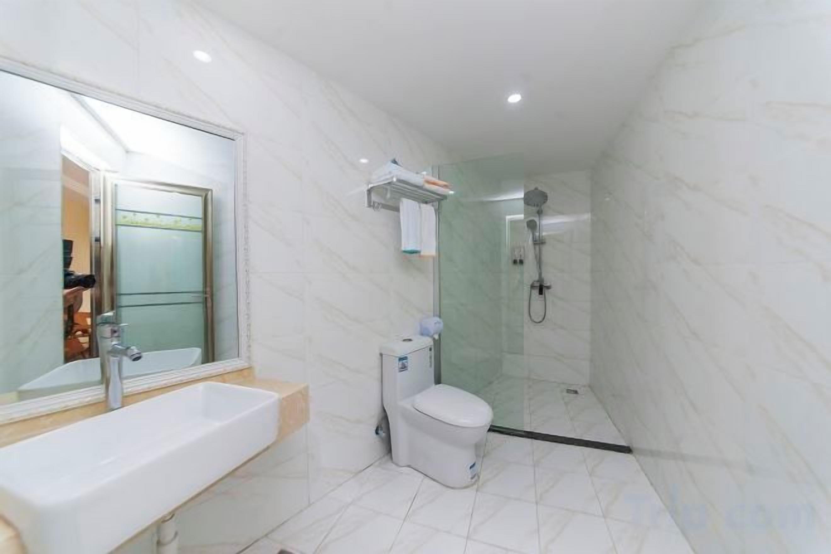 Uma casa de banho com lavatório, sanita e chuveiro.