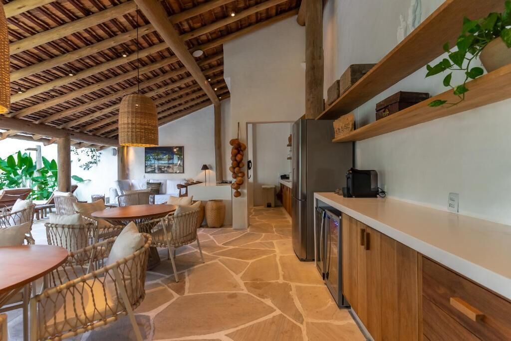 Uma cozinha moderna com piso de pedra, teto de madeira e eletrodomésticos embutidos.