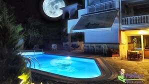 Um edifício de dois andares com piscina, varanda e uma placa com o texto "Melissa Gold Coast".