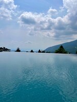 Vista nítida de uma piscina com paisagem montanhosa ao fundo.