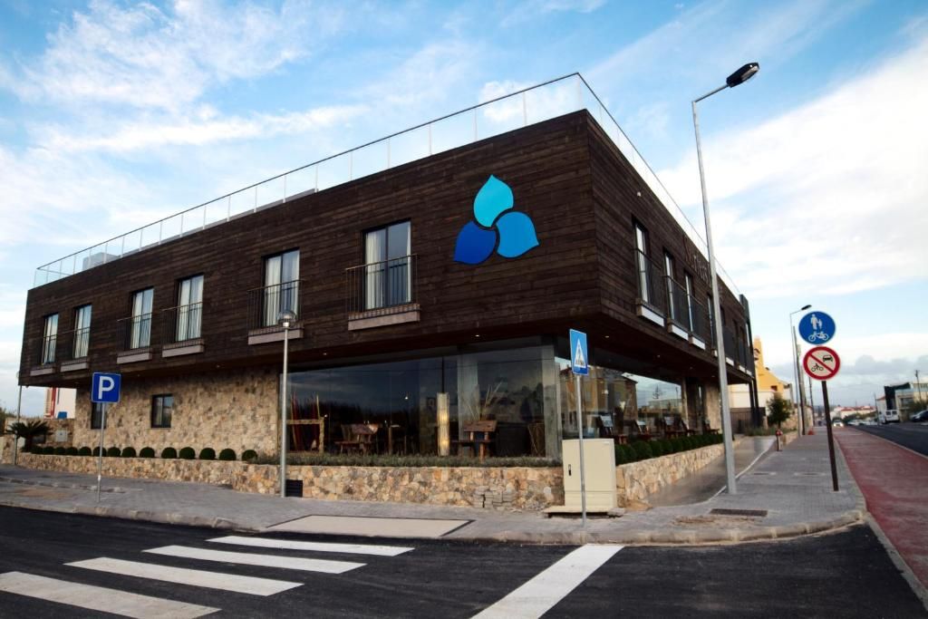 Um edifício moderno com fachada de madeira, um logotipo azul e uma faixa de pedestres.