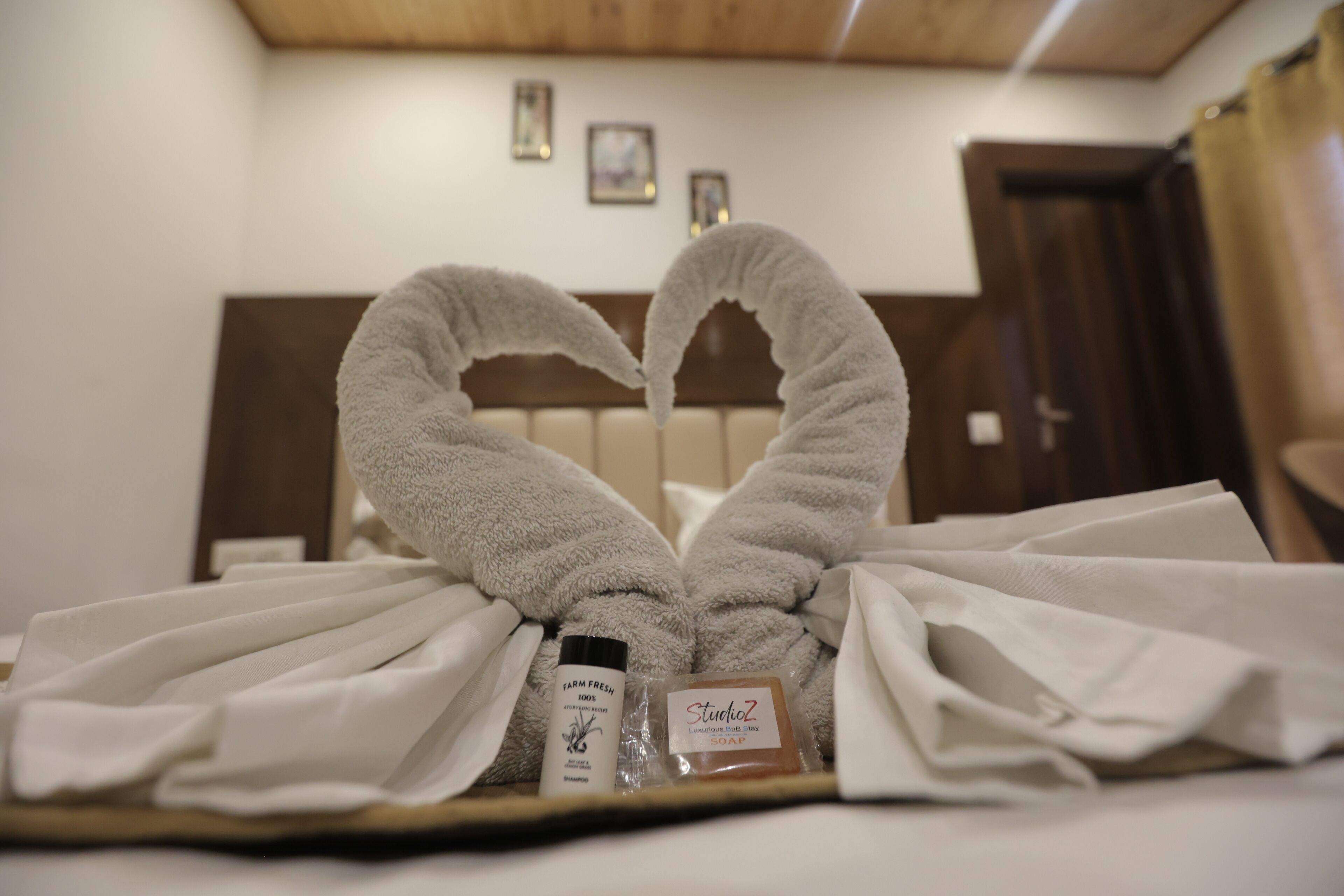 Quarto com uma cama, cabeceira de madeira e parede com quadros.