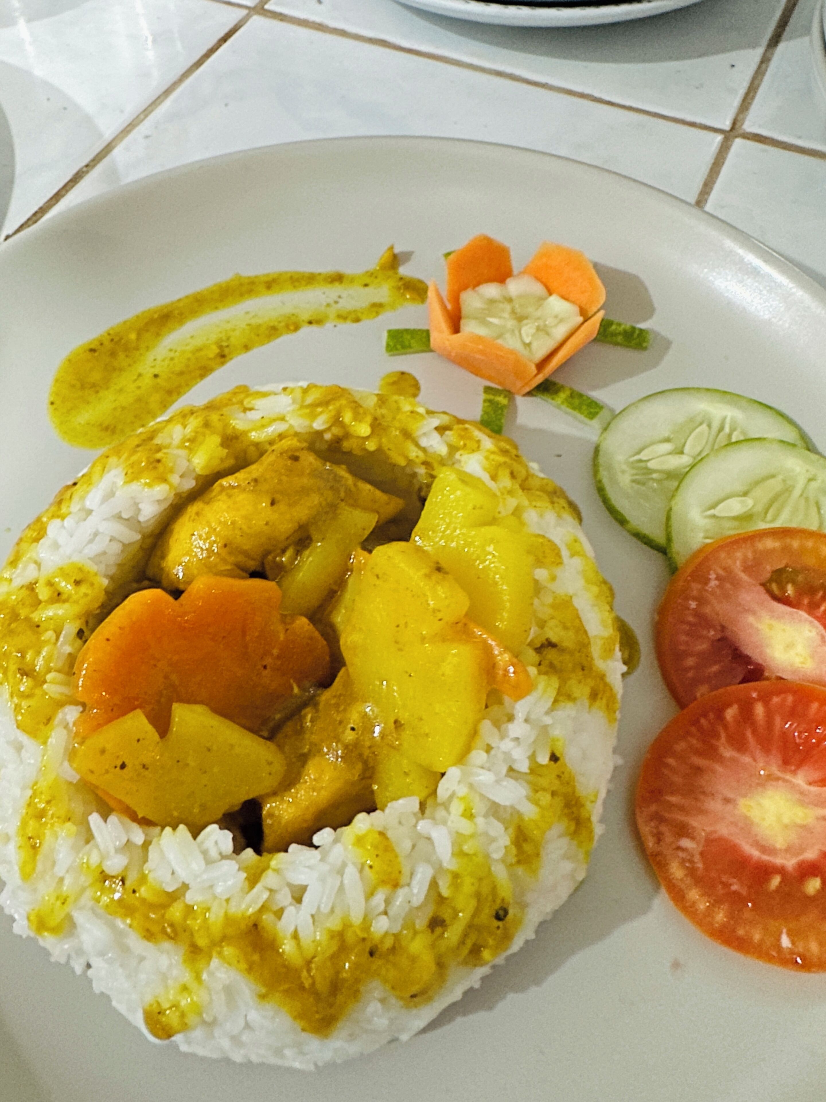 Prato de comida com arroz, legumes e um prato de curry.
