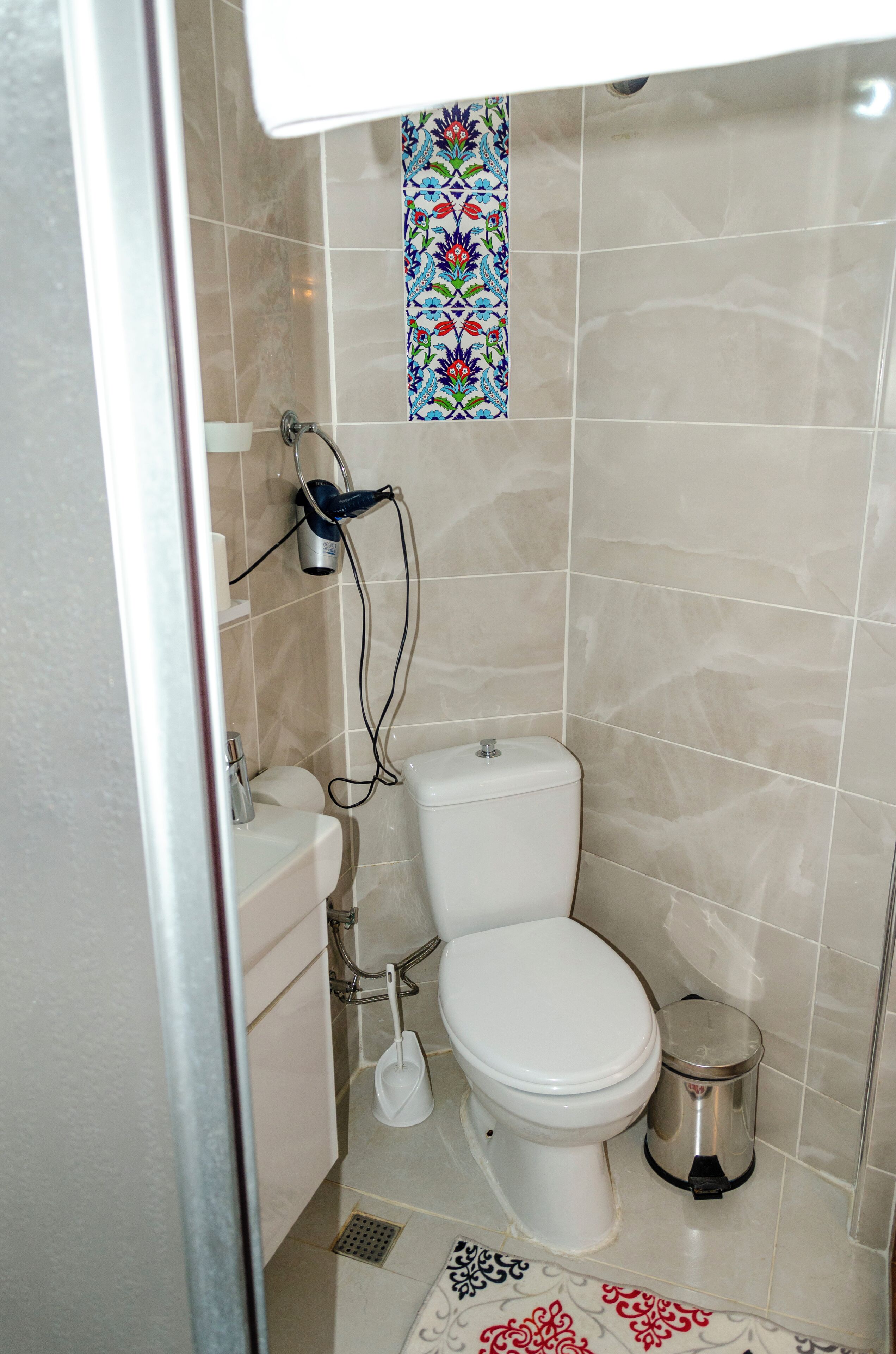 Casa de banho com sanita, bidé, um lixo e um chuveiro.